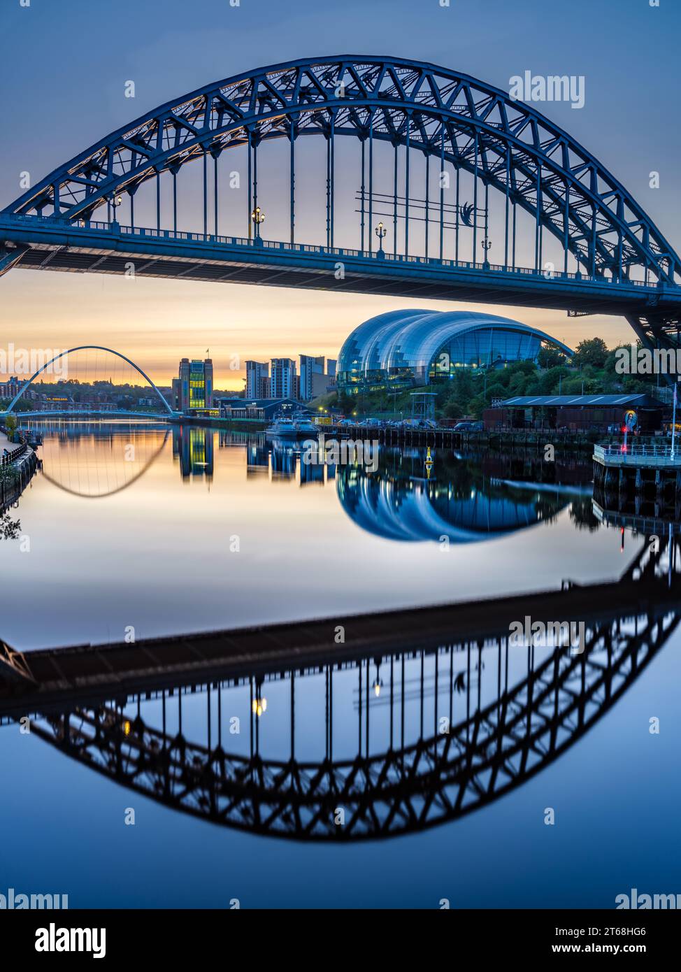 The Tyne Bridge reflected in the River Tyne at dawn with the ...