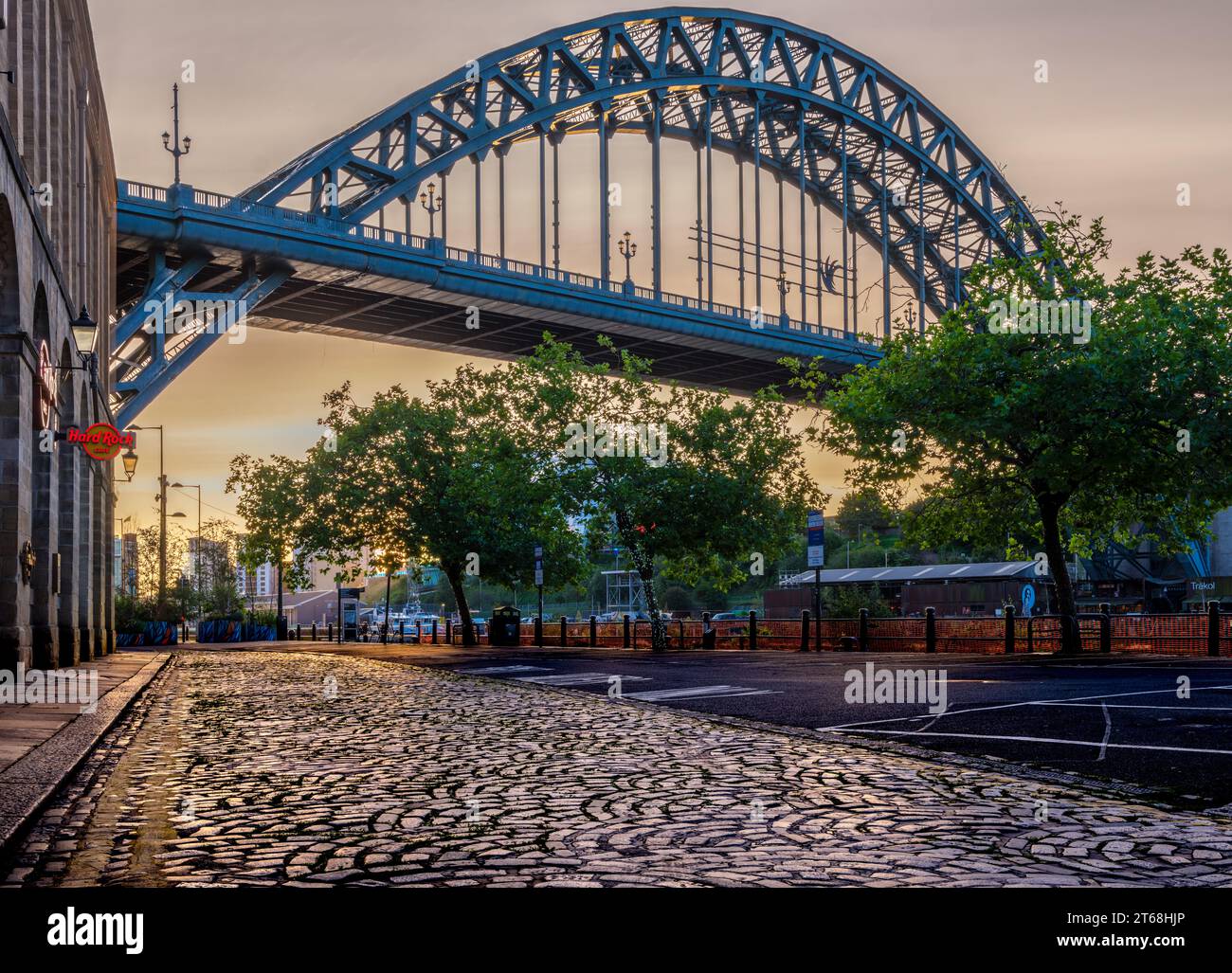 Low angle shot of Tyne Bridge with cobbled street of NEwcastle Quayside ...