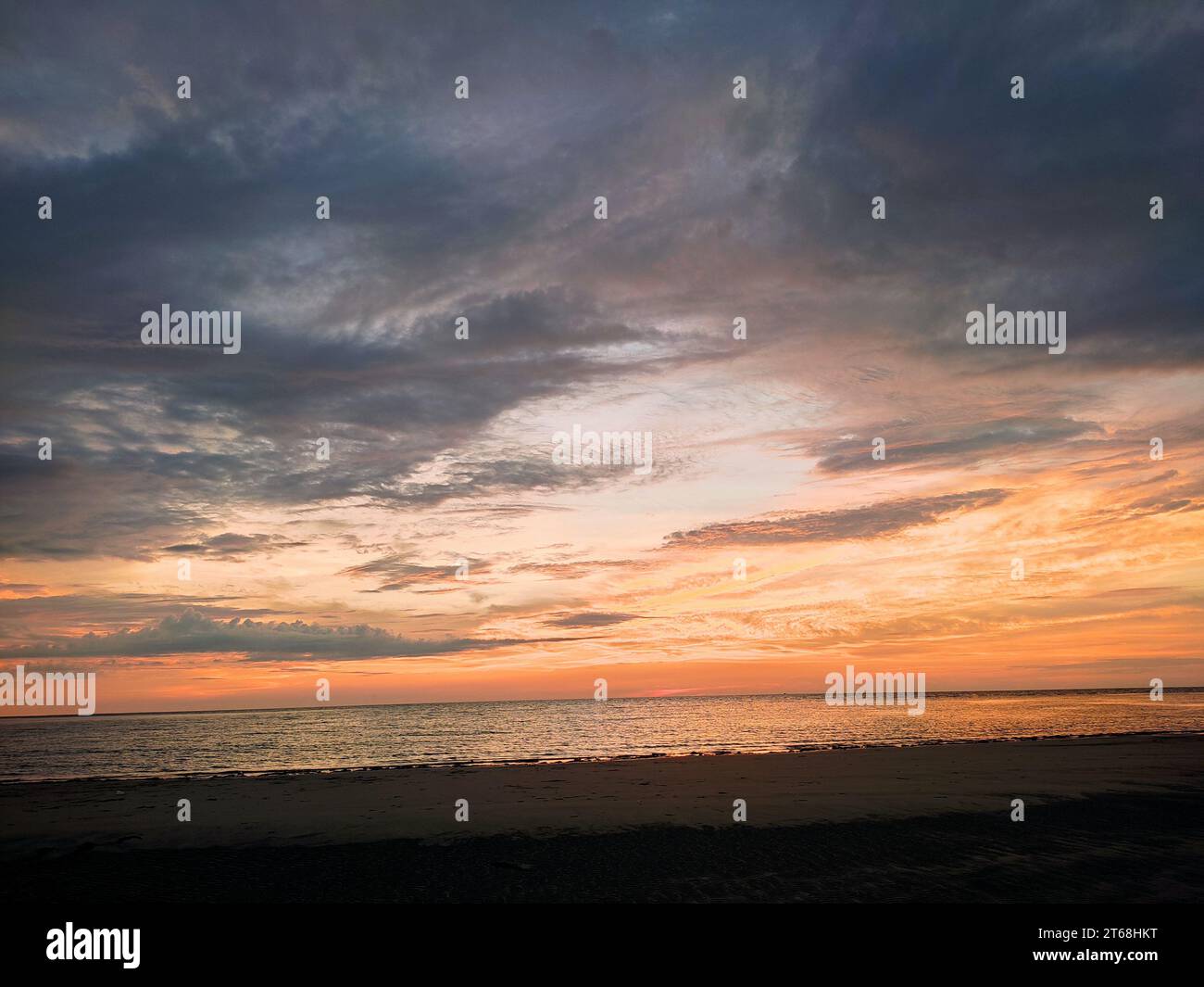 A spectacular evening beach scene featuring a vibrant orange and red ...