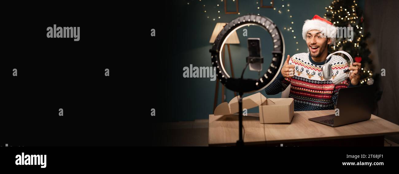 Arabic Santa Claus filming video on phone camera while opening parcel ...