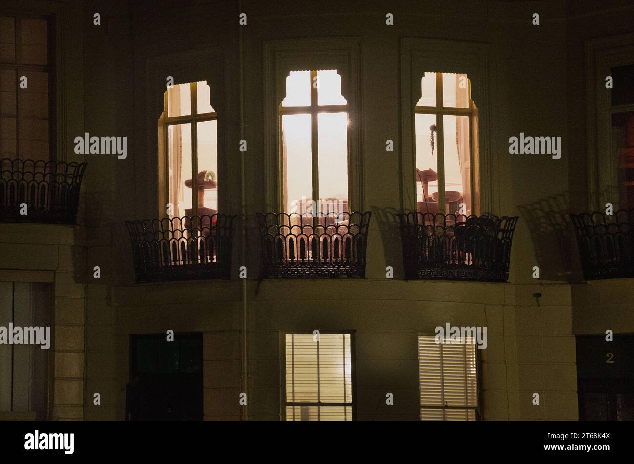 A group of people are gathered in the windows of a multi-story ...