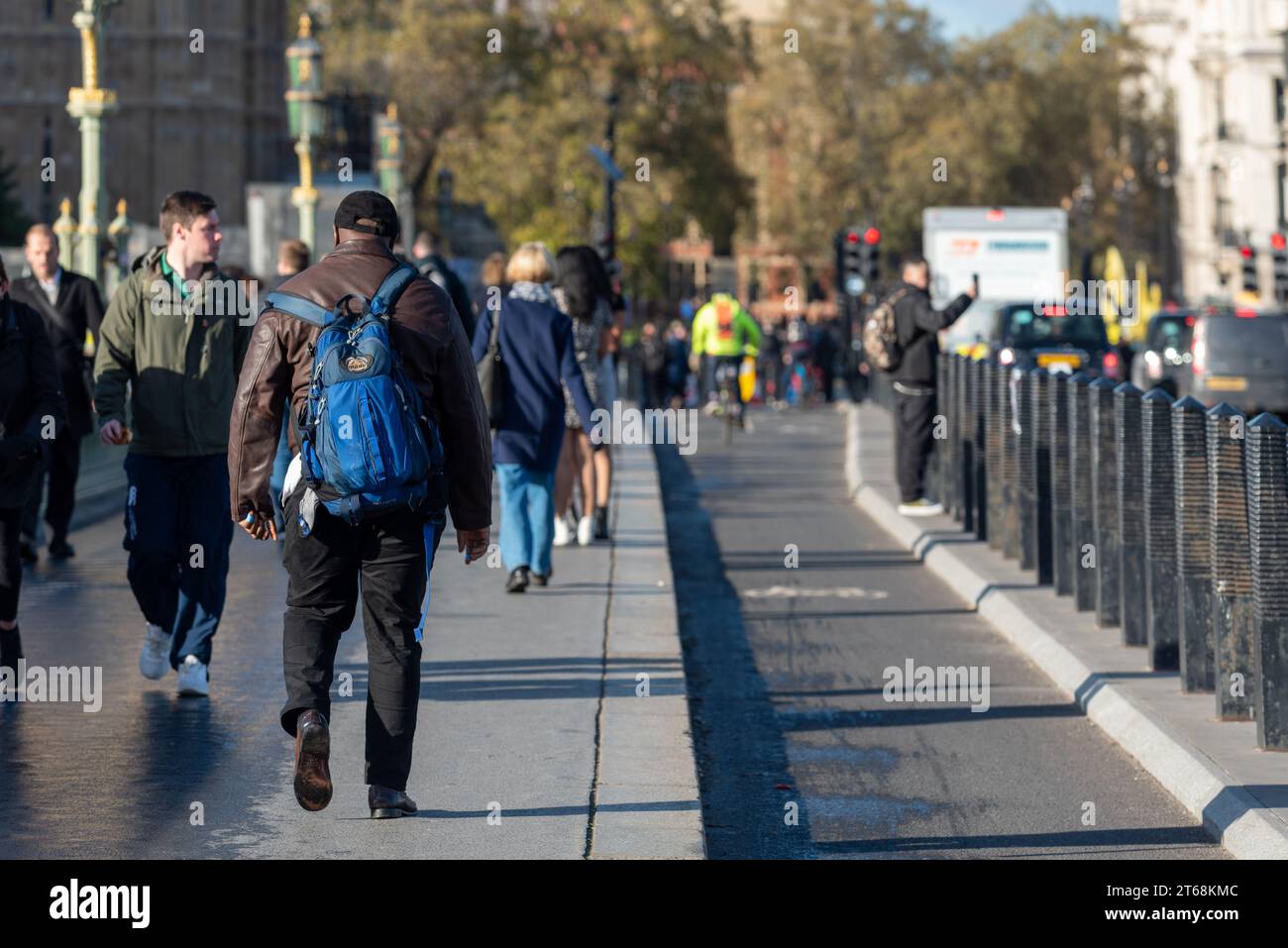 Pedestrians and cyclists crossing Westminster bridge towards Big Ben ...
