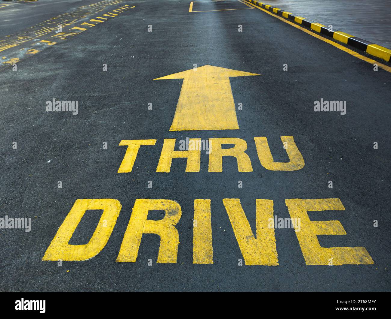 Asphalt road with yellow drive thru signage Stock Photo - Alamy