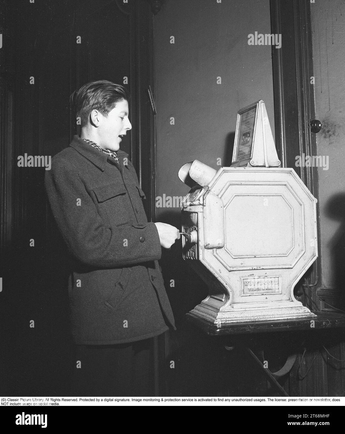 Young man at a Mutoscope, an early motion picture divice invented in ...