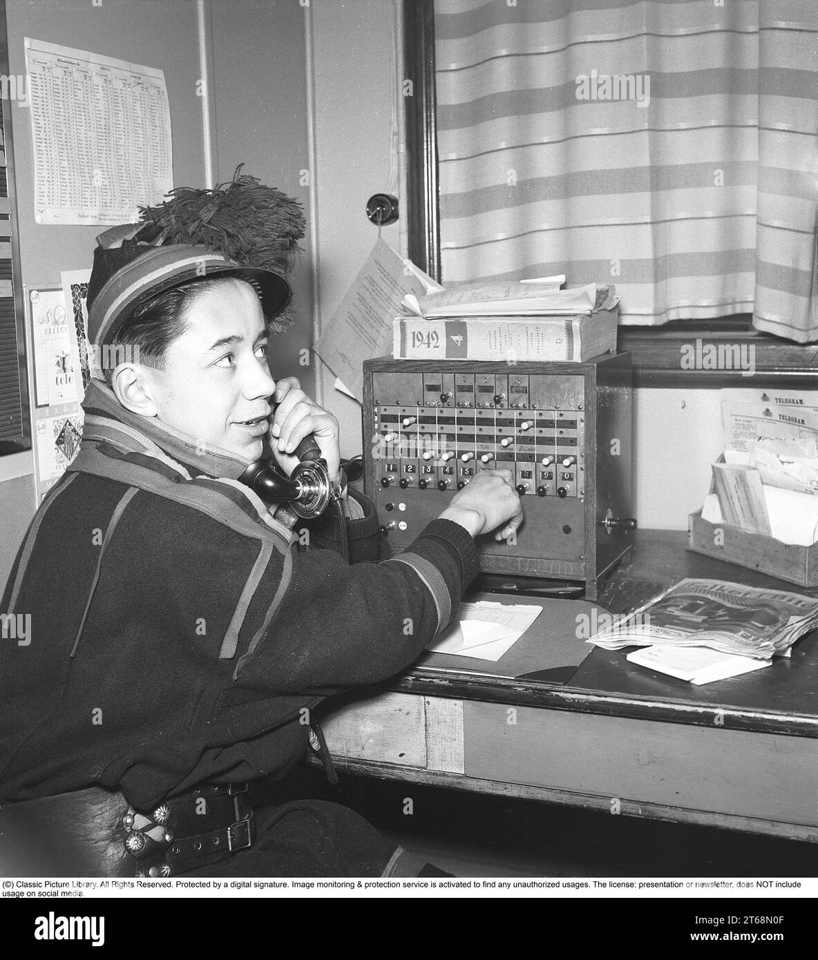 Telephony in the 1940s. A man in a traditional sami clothing at a ...