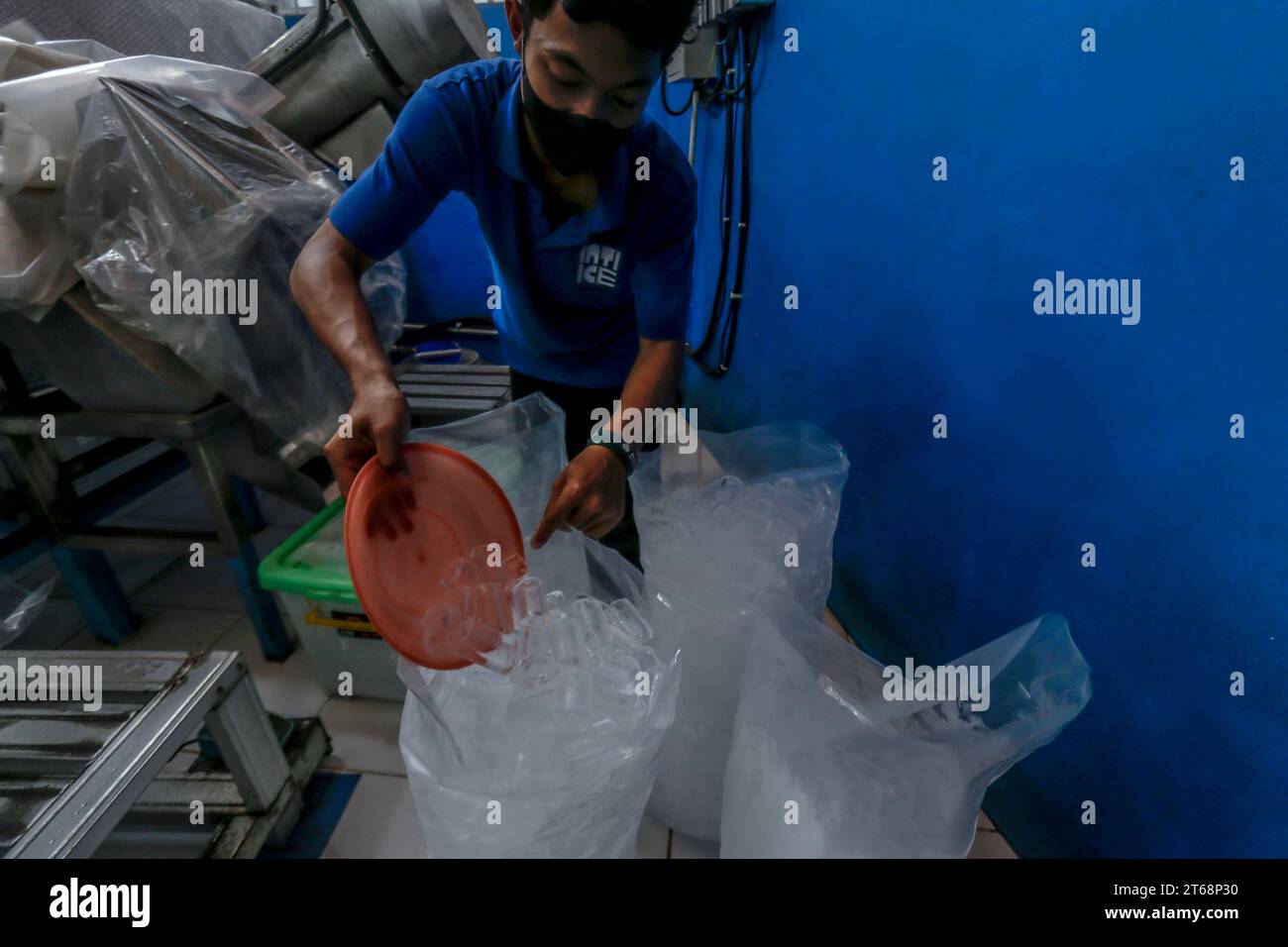 Workers pack crystal ice cubes at a crystal ice cube factory in Bogor ...