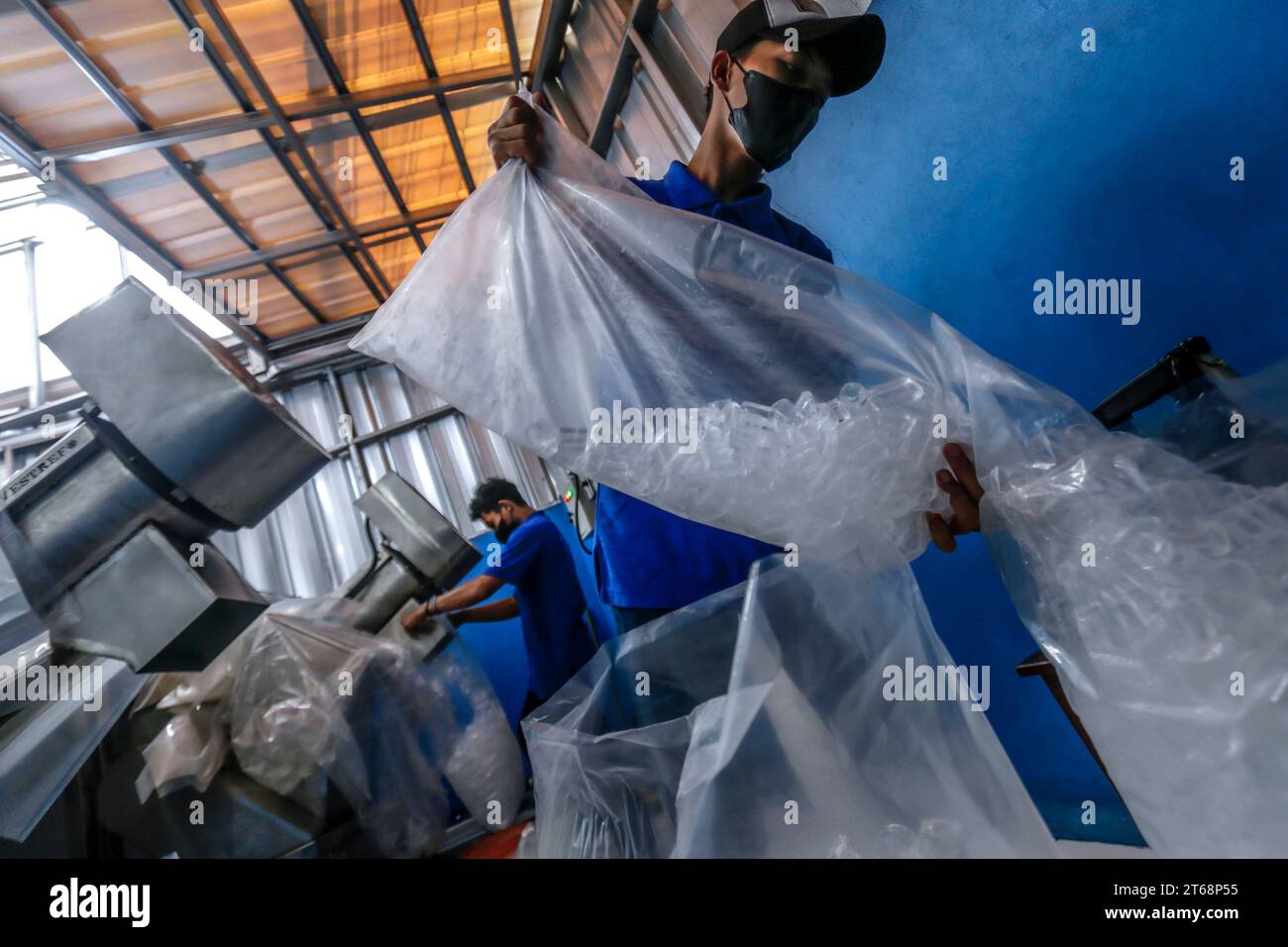 Workers pack crystal ice cubes at a crystal ice cube factory in Bogor ...
