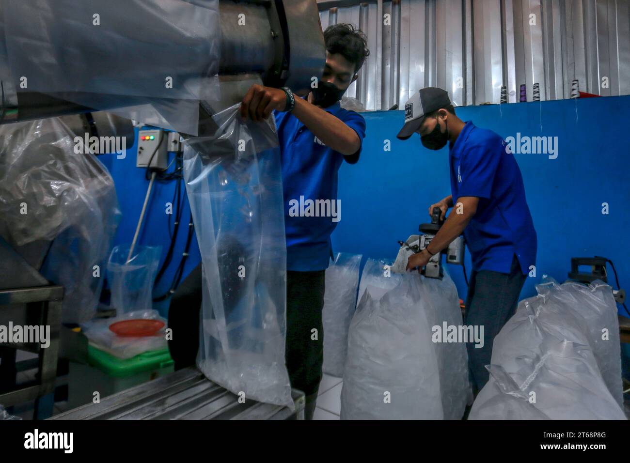 Workers pack crystal ice cubes at a crystal ice cube factory in Bogor ...