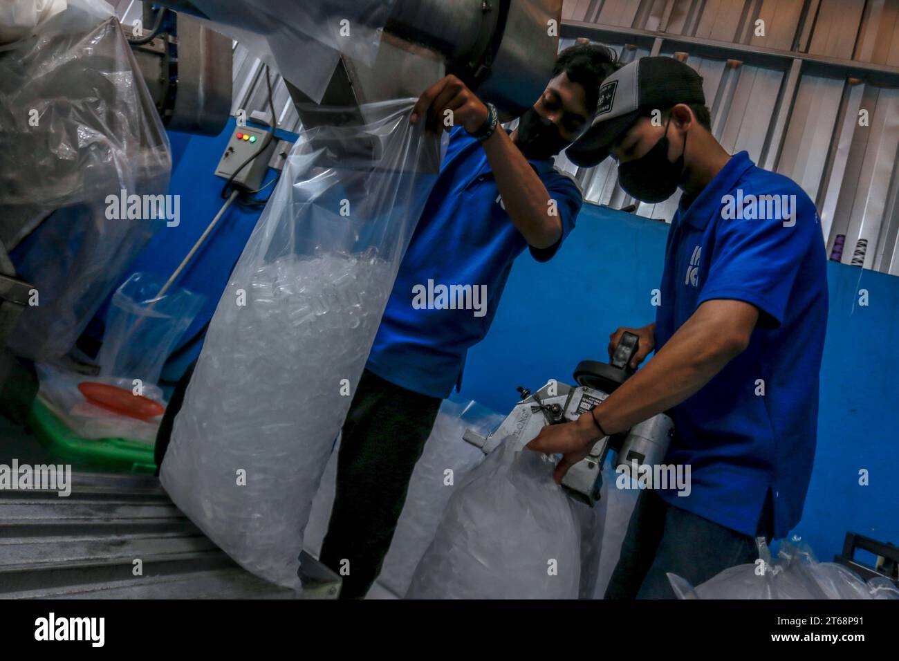 Workers pack crystal ice cubes at a crystal ice cube factory in Bogor ...