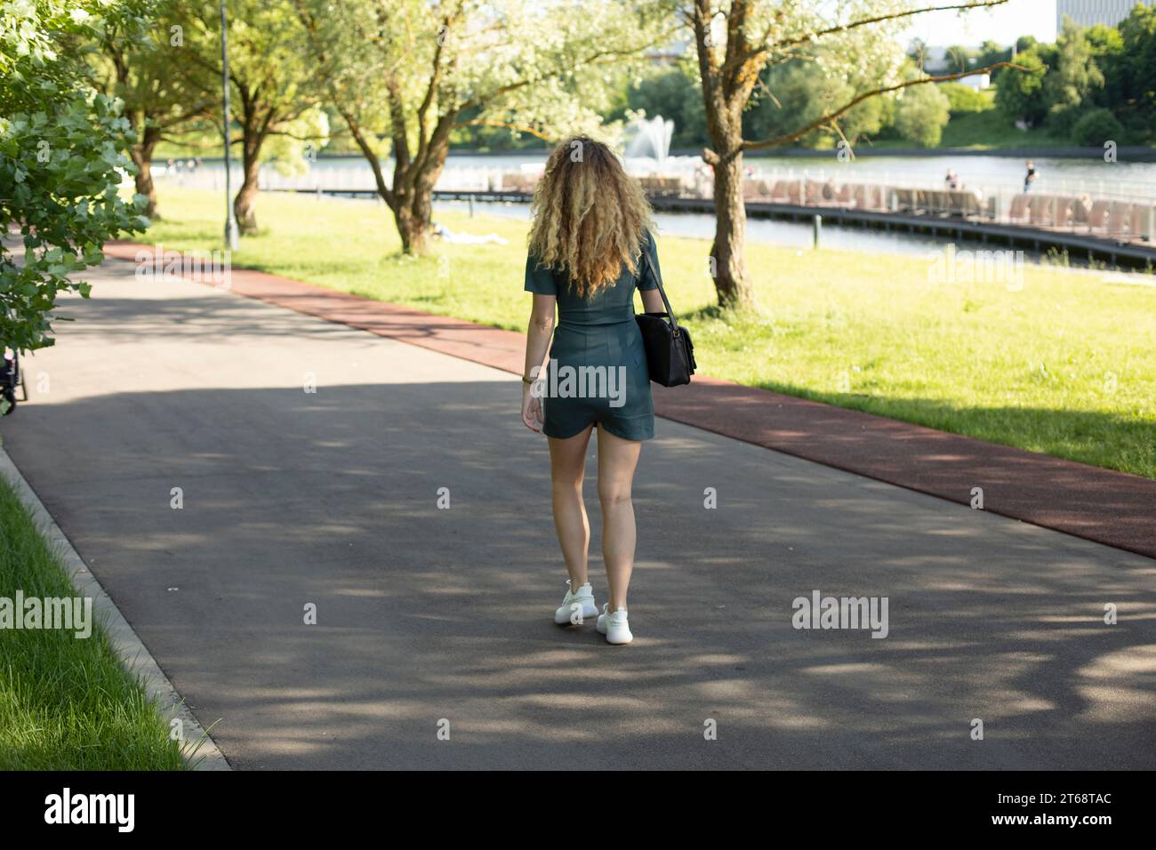 Girl walks through park in summer. Walk in summer on street. Shooting ...