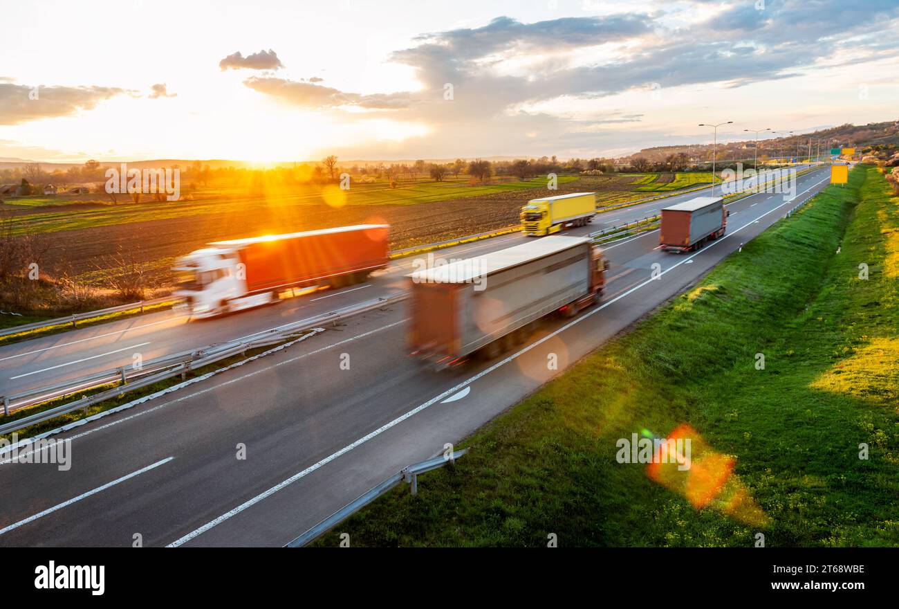 Transportation trucks in high speed driving on a highway through rural ...
