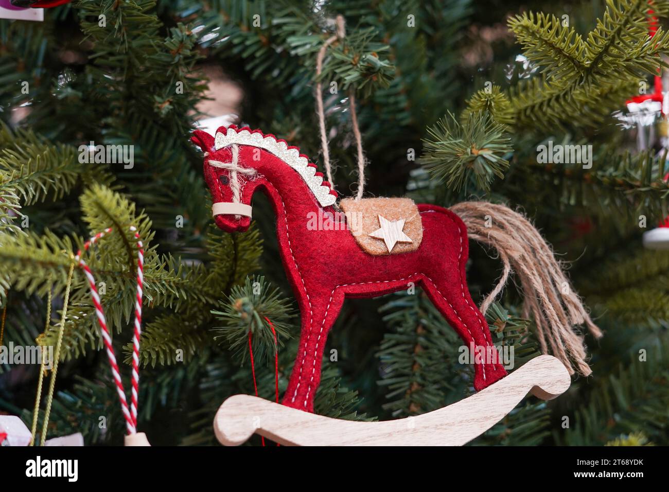 a wooden red horse toy on a Christmas tree, New Year card Stock Photo ...