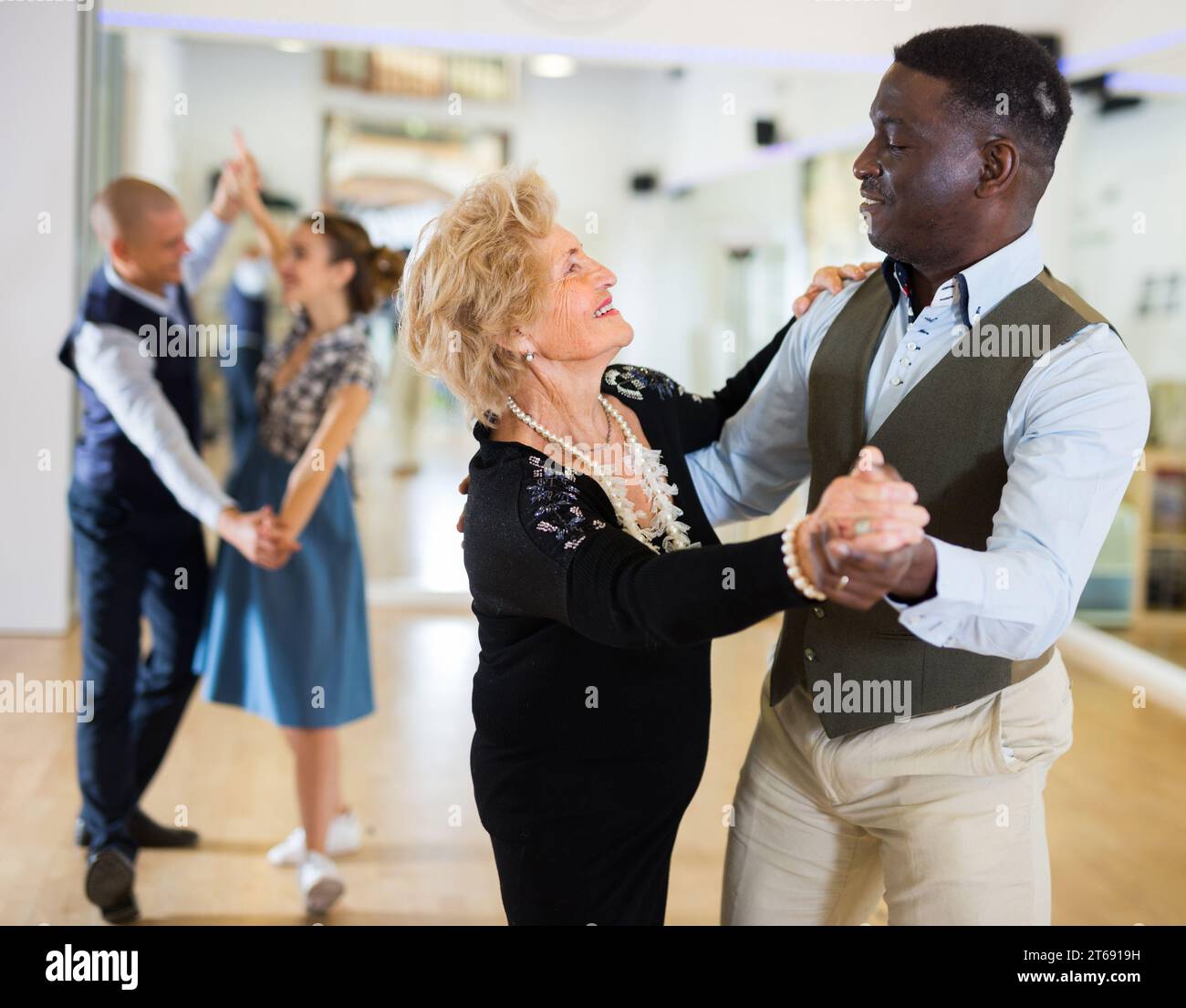Elderly woman learning ballroom dancing in pair in dance studio Stock ...