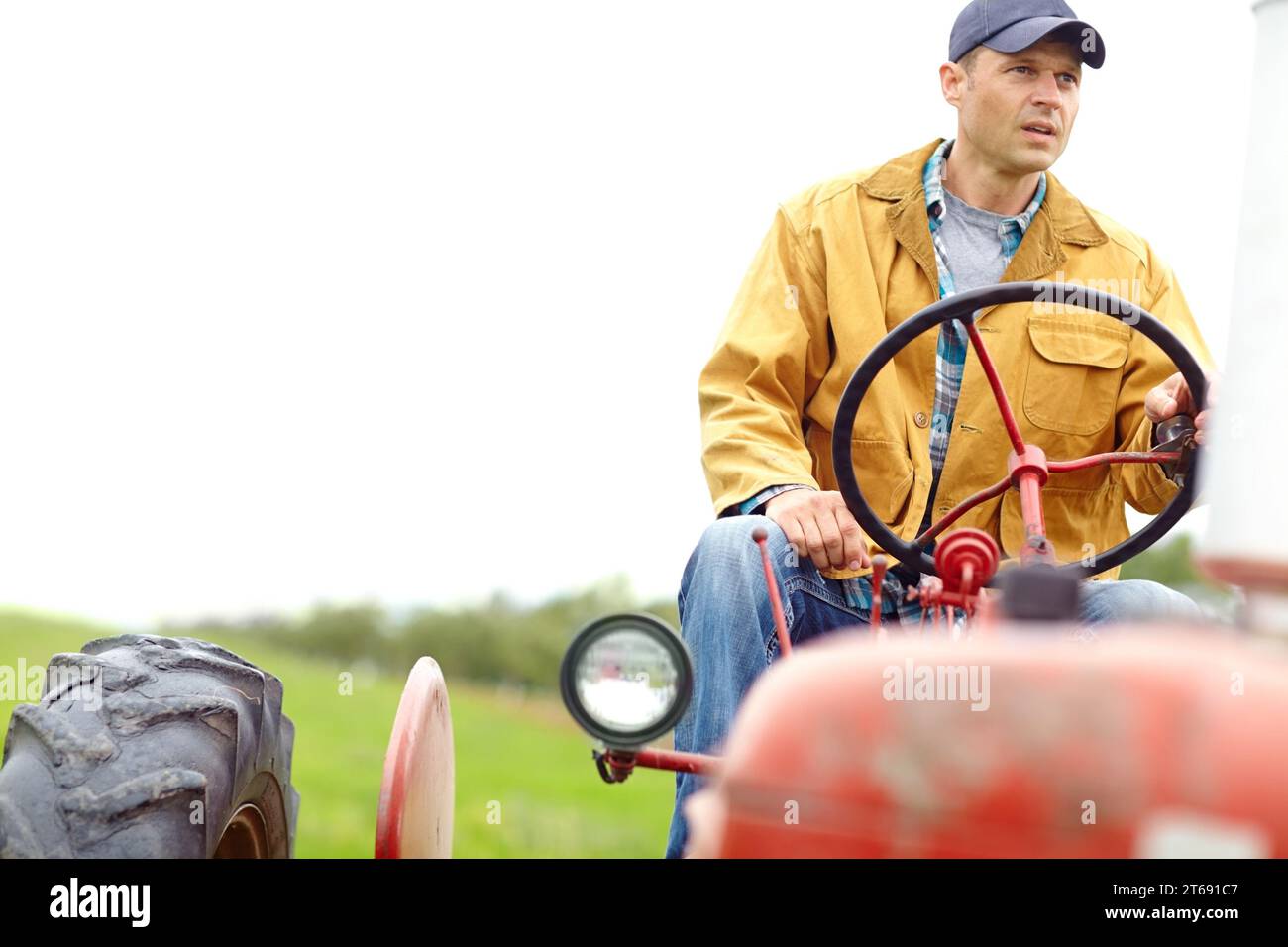 Providing for my family. A farmer driving his tractor on an open field ...