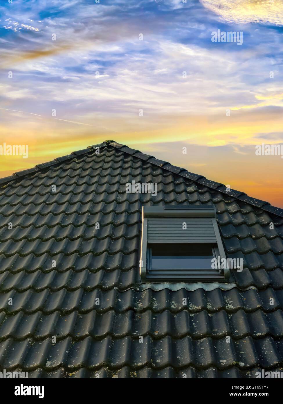 Open roof window in velux style with black roof tiles Stock Photo - Alamy
