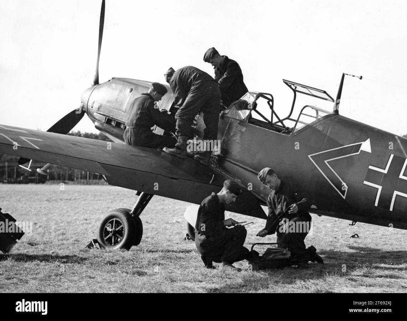 Wait at a Messerschmitt Me BF 109 of the German Luftwaffe in black paint on a field airfield ...