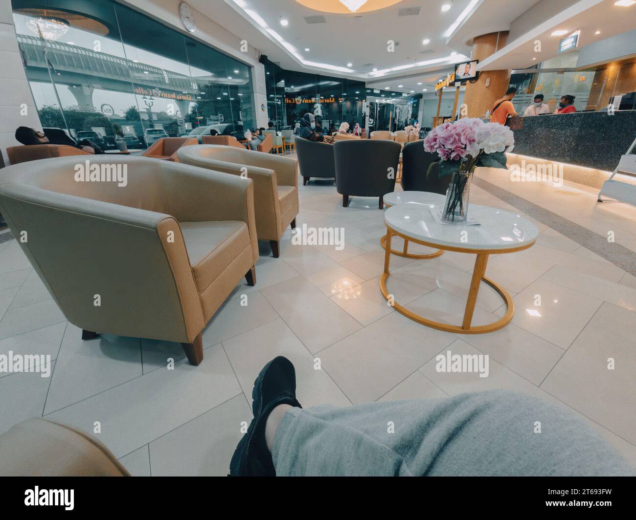 A person is comfortably seated in a living room setting with their feet ...