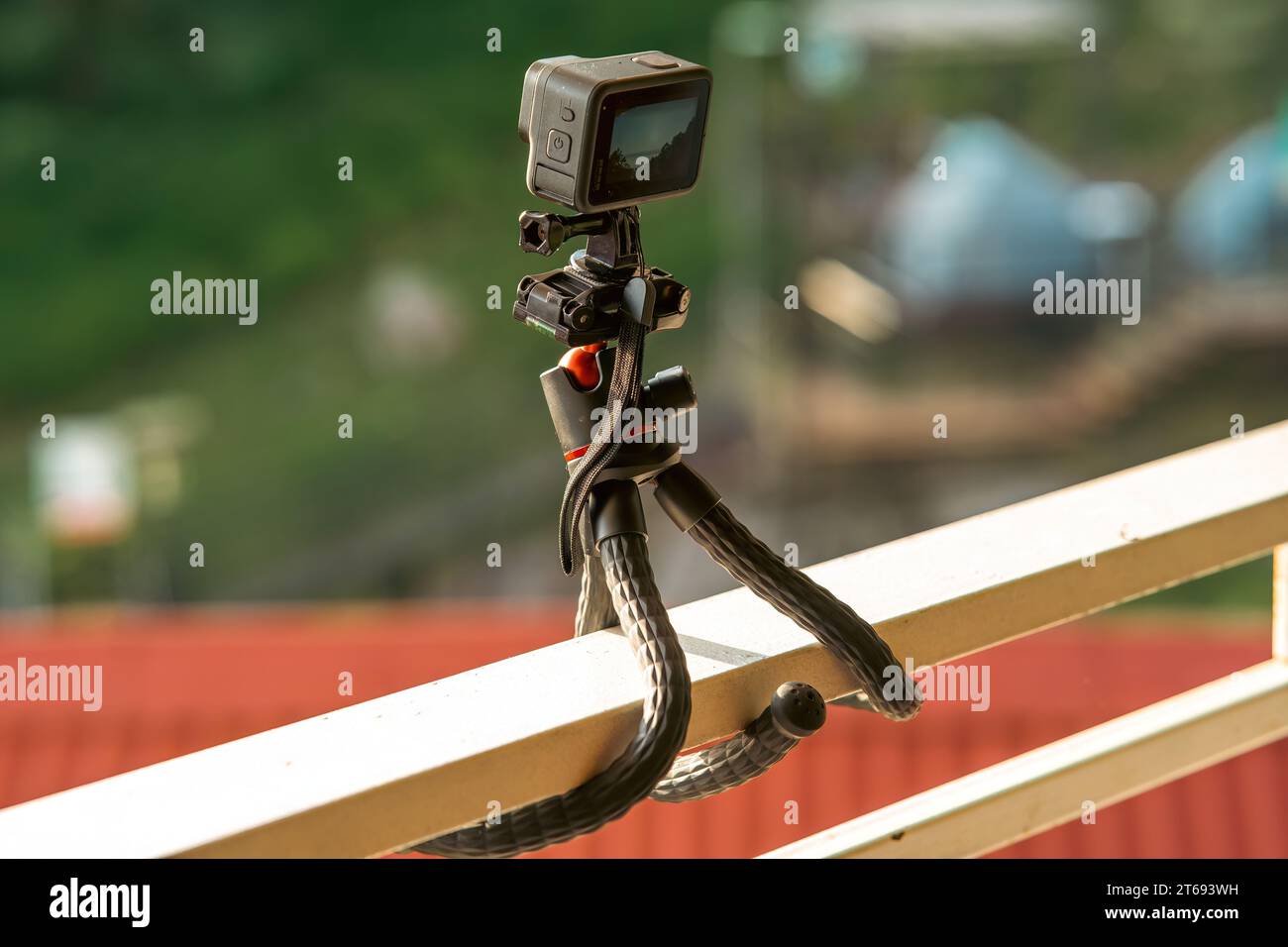 A professional-grade video camera is securely mounted on a railing of ...