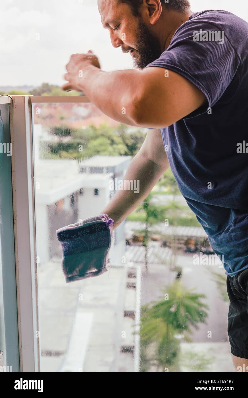 A young man wearing safety glasses and a blue work vest is standing on ...