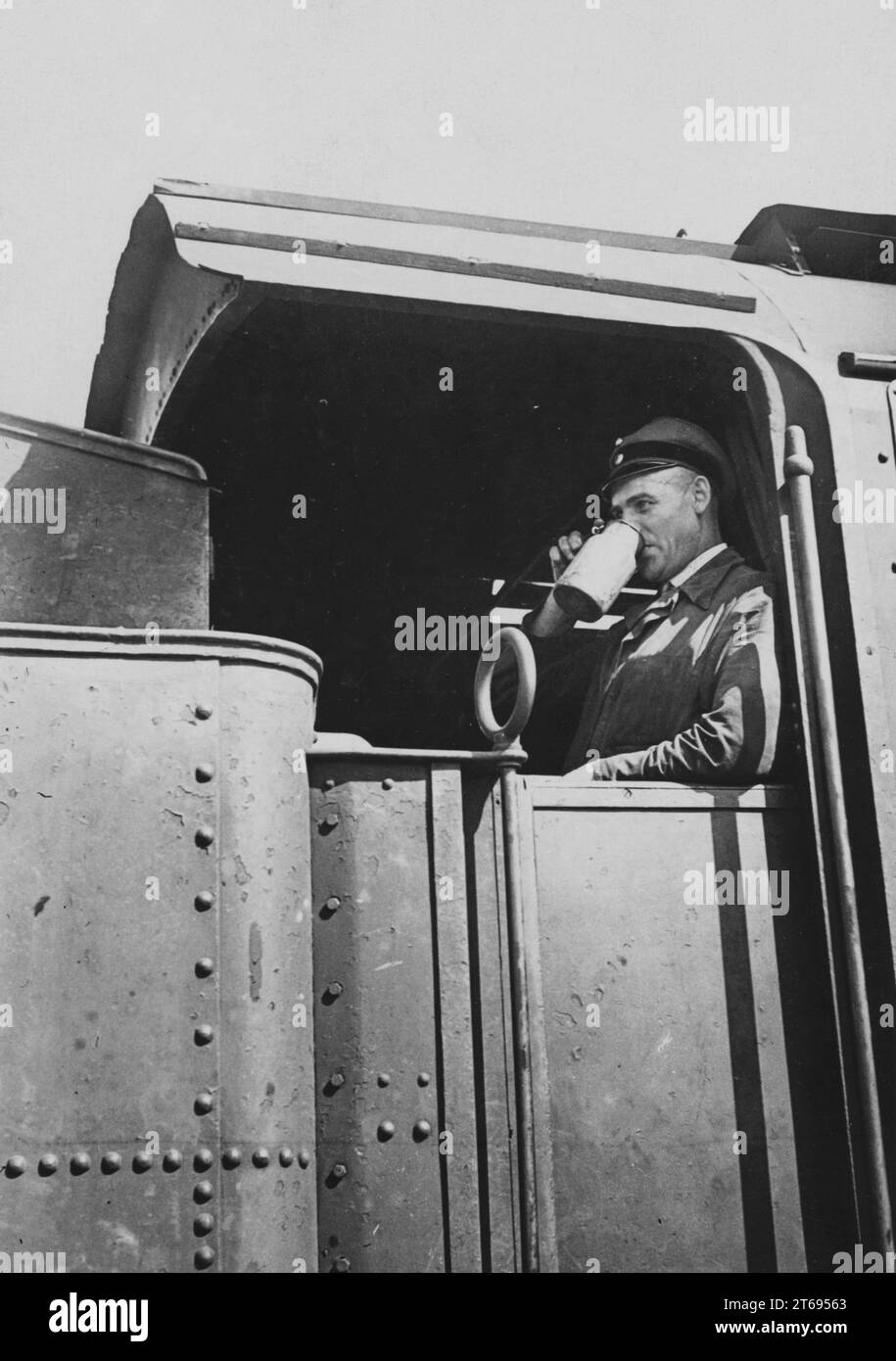 Locomotive driver drinking during a stop at Anhalter station ...