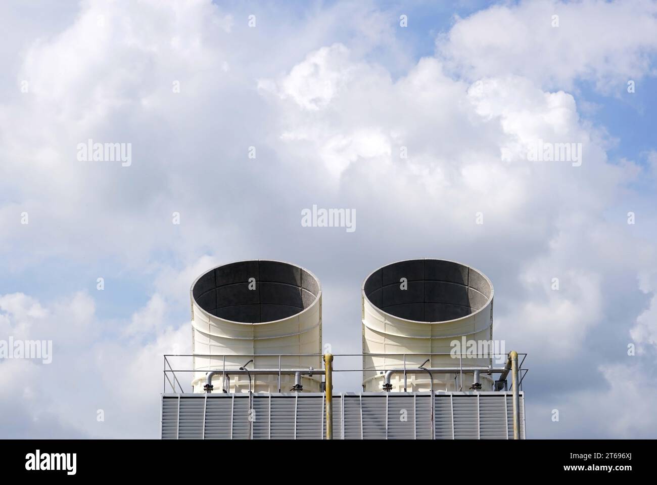 Industrial big chimneys against the blue sky with white clouds ...