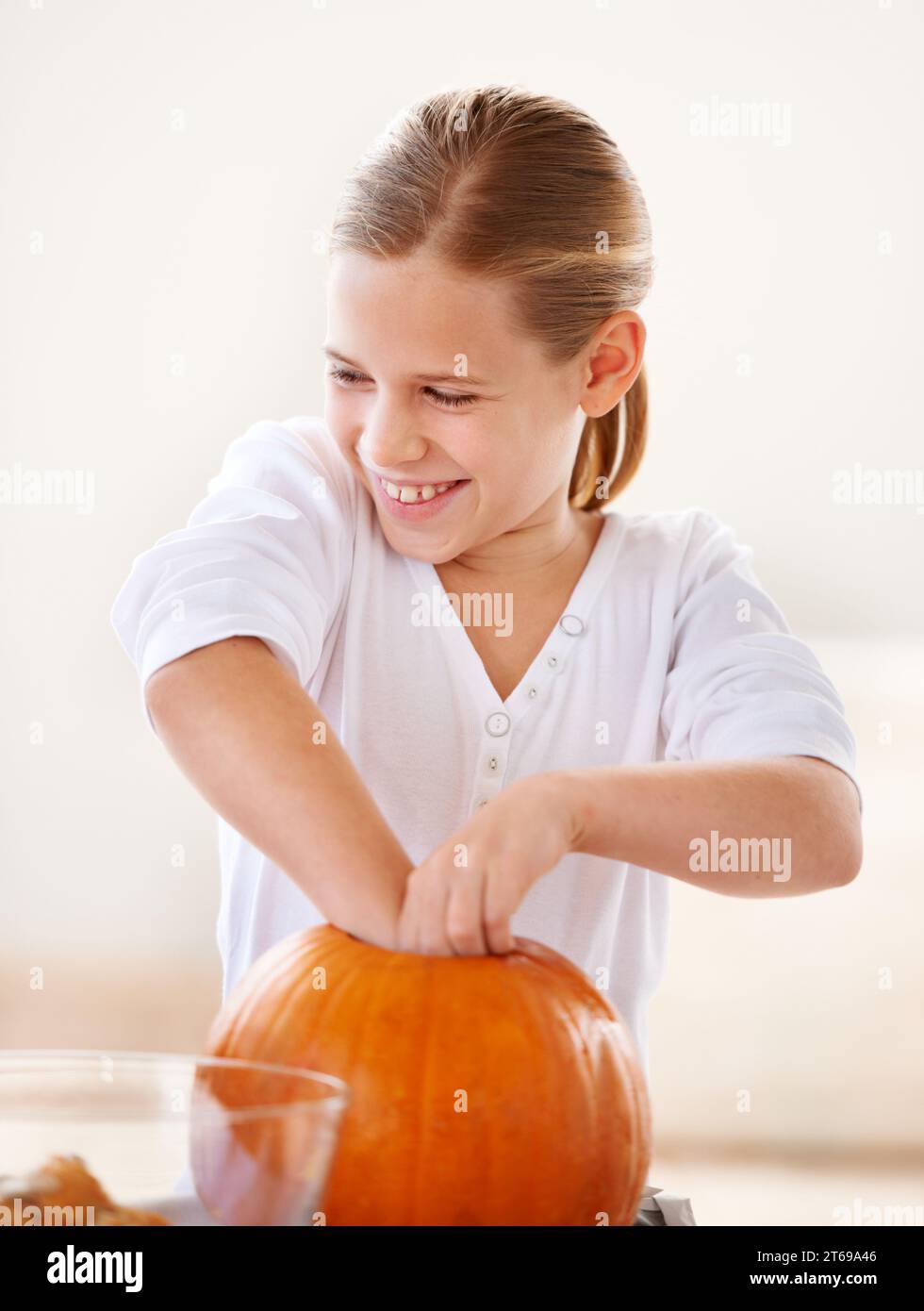Hollowing out a pumpkin for a jack-o-lantern. A little girl hollowing ...