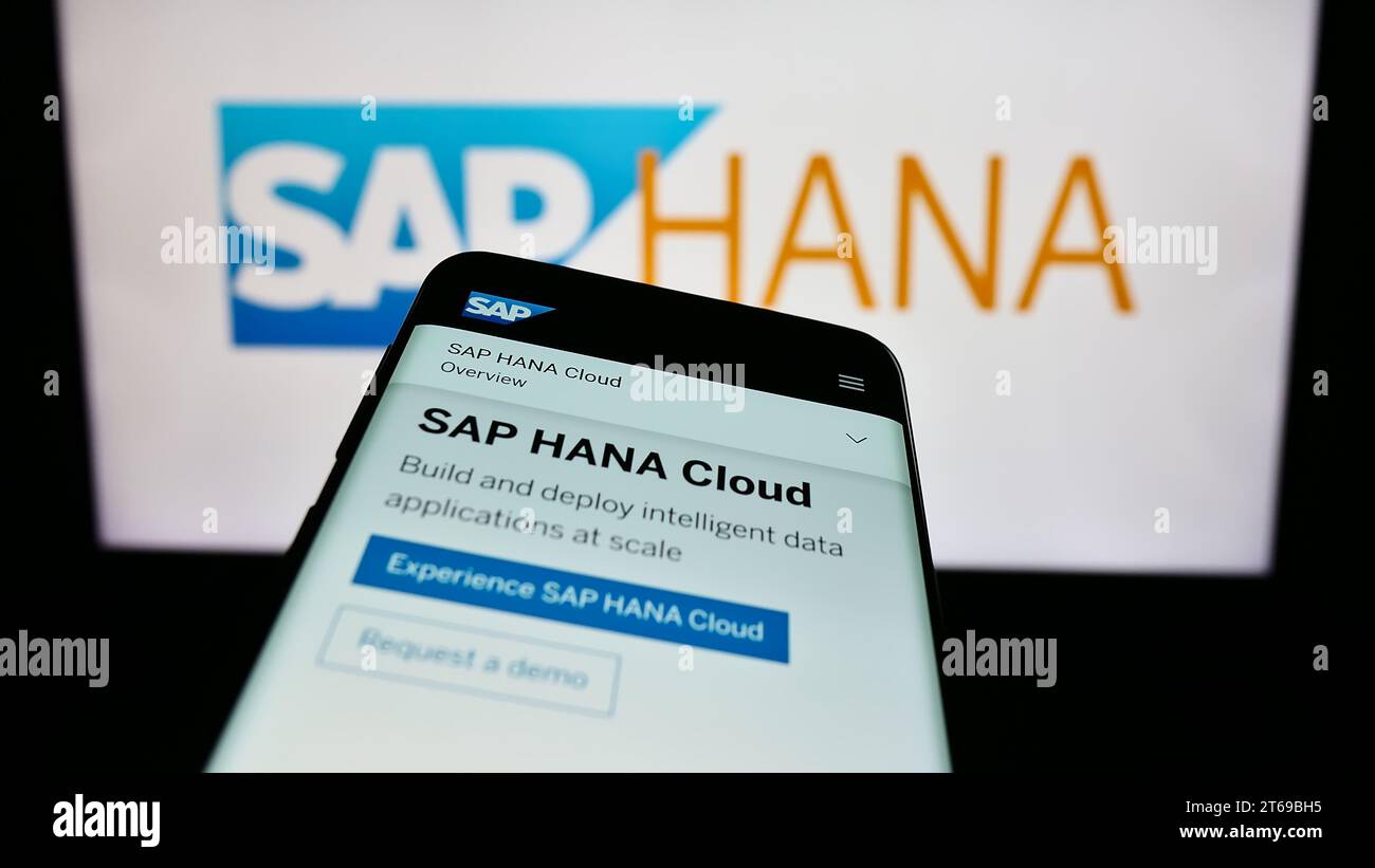 Smartphone with website of database management software SAP HANA in front of company logo. Focus ...
