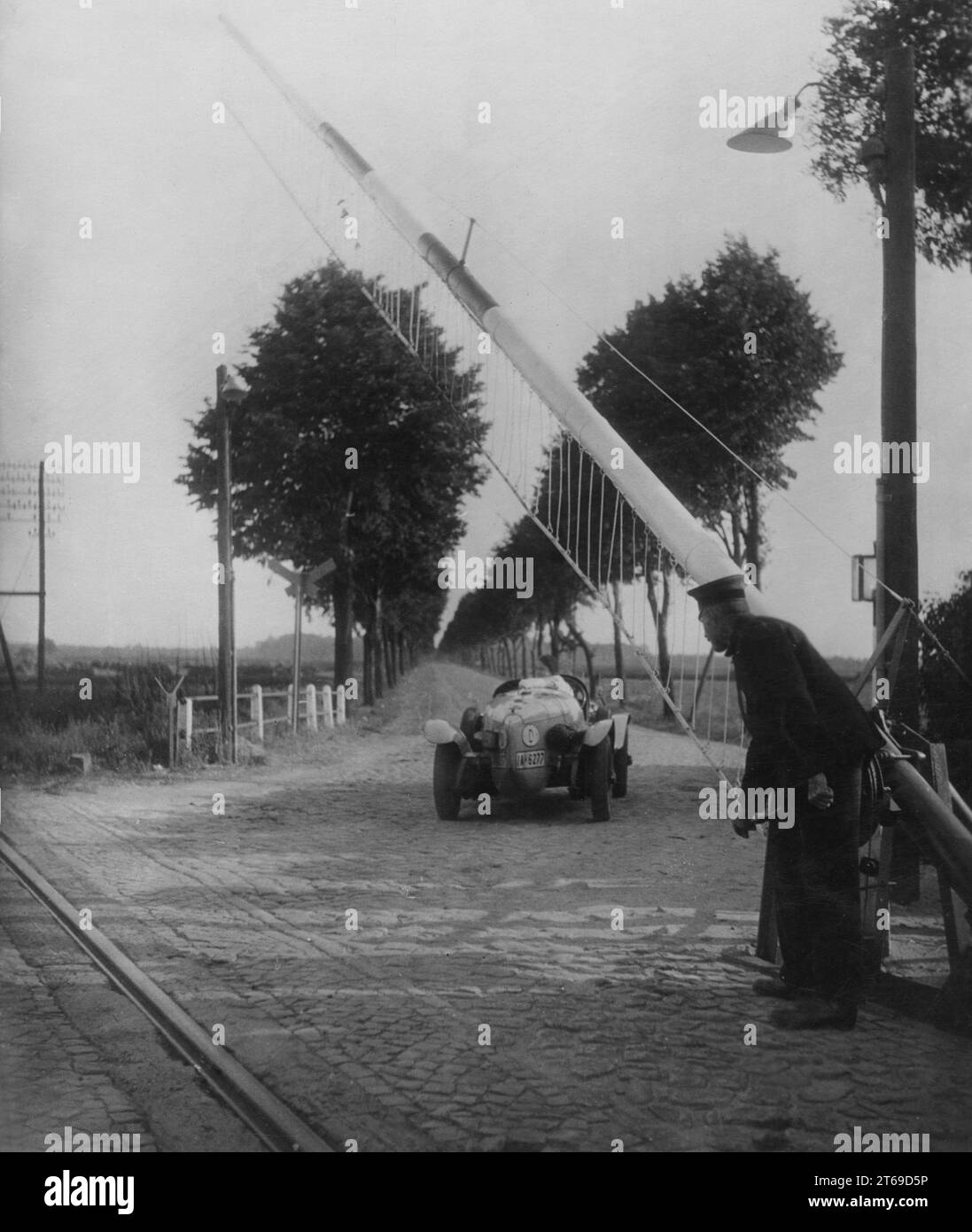 A crossing guard closes the barrier of the level crossing after a woman ...