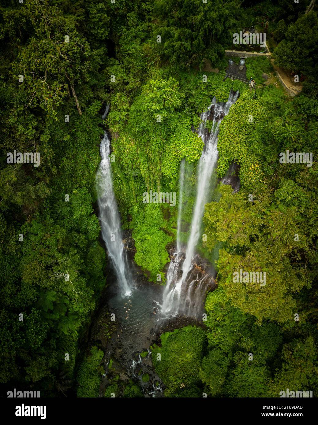 A peaceful landscape featuring two cascading waterfalls flowing down ...
