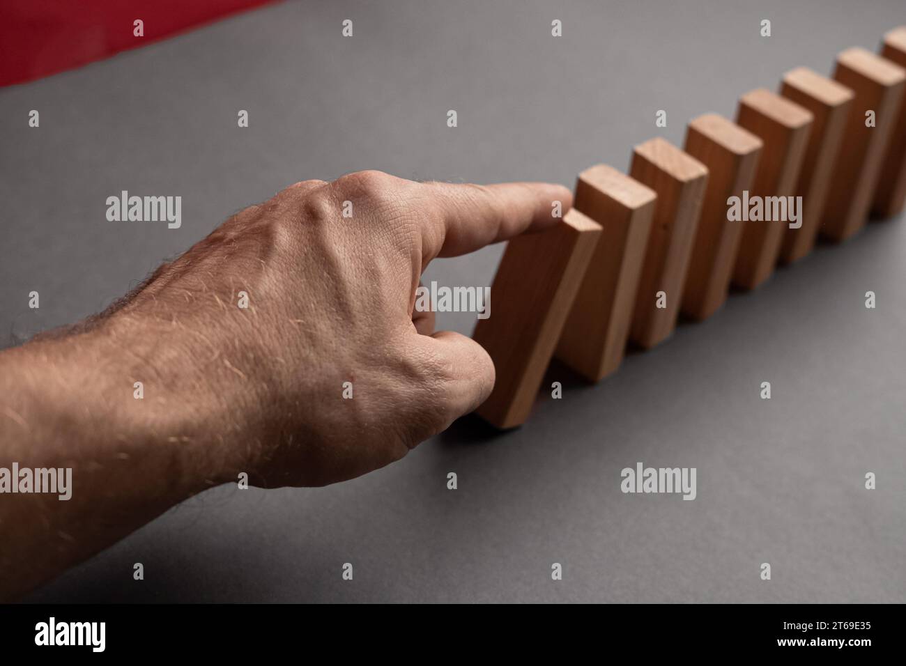 Domino has Fallen in a Row. Domino theory. Effect. Hand with Finger is ...