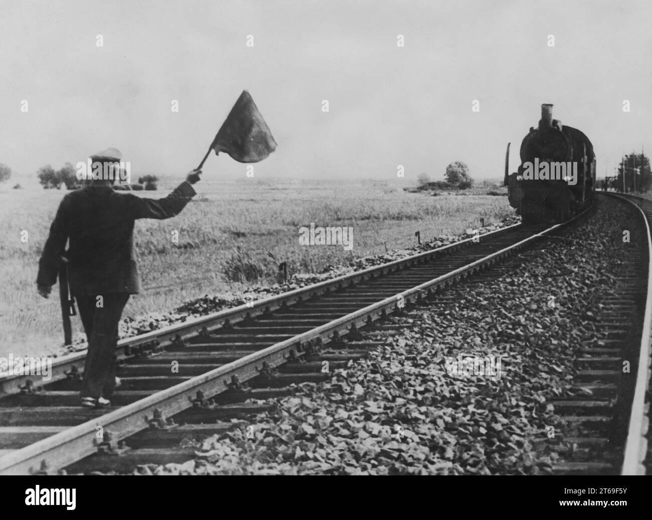A track runner of the Deutsche Reichsbahn gives a stop signal to the ...