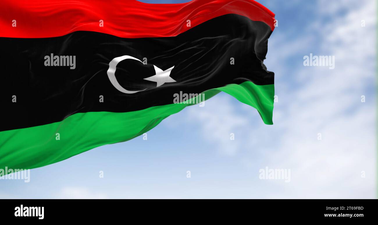 National flag of Libya waving on a clear day. Red, black, green stripes ...