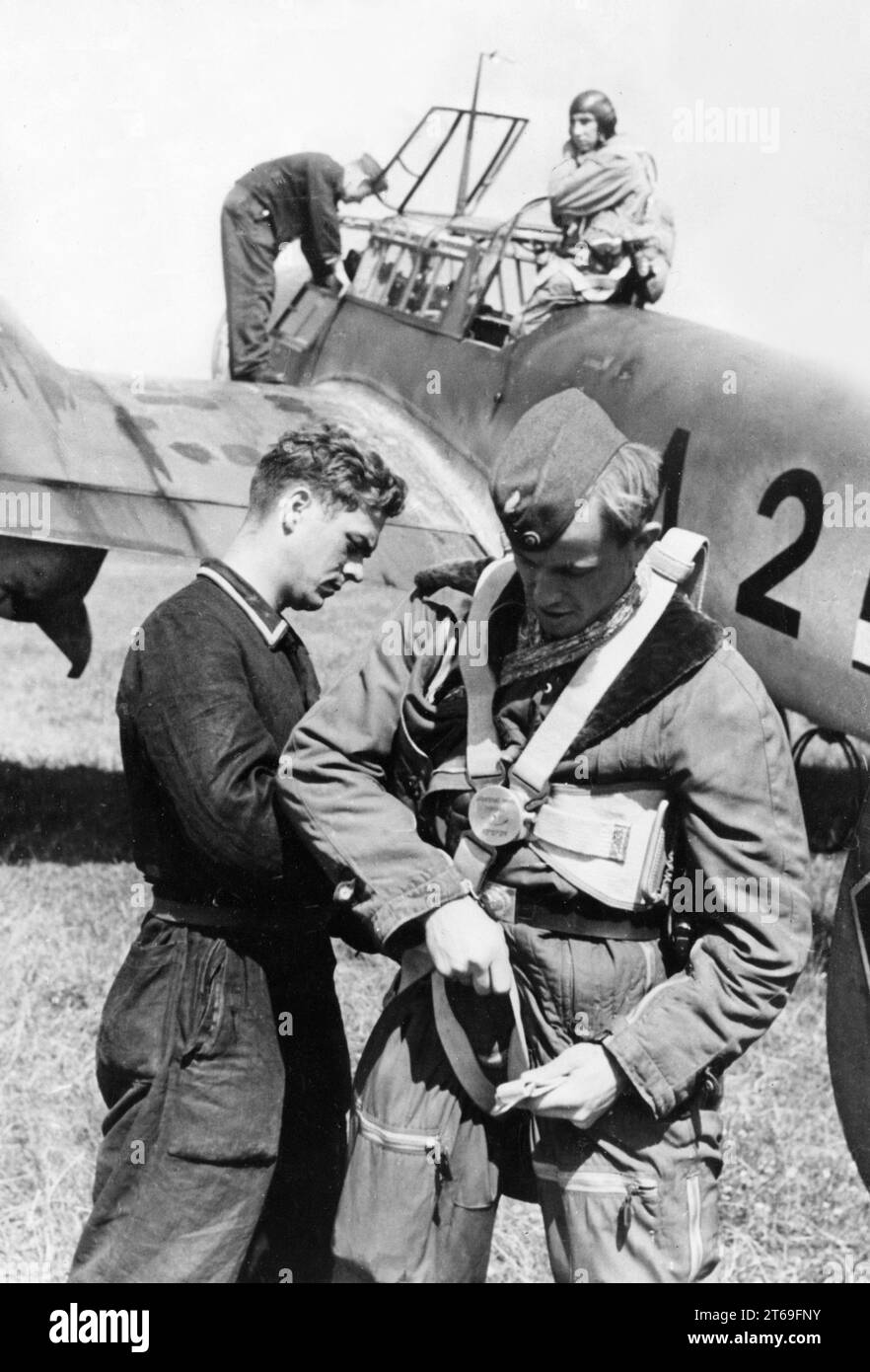 The pilot of a German Messerschmitt Me 110 puts on his parachute ...