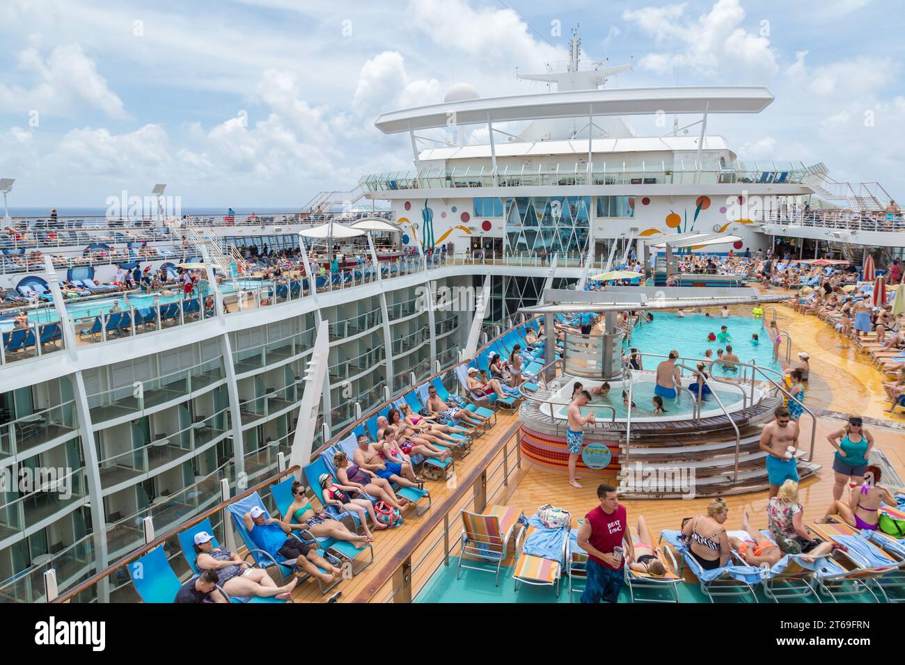 Cruise passengers enjoying the pool deck on the Royal Caribbean Allure ...