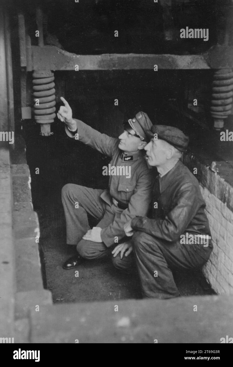 A German railroad worker in a railroad repair shop with a French worker ...
