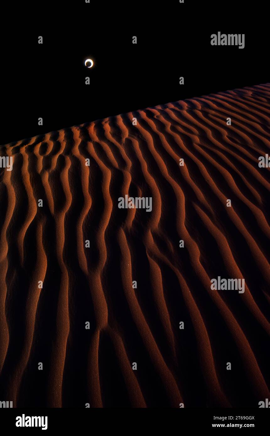 Iron-stained sand dune with annular eclipse, Monument Valley, Arizona ...