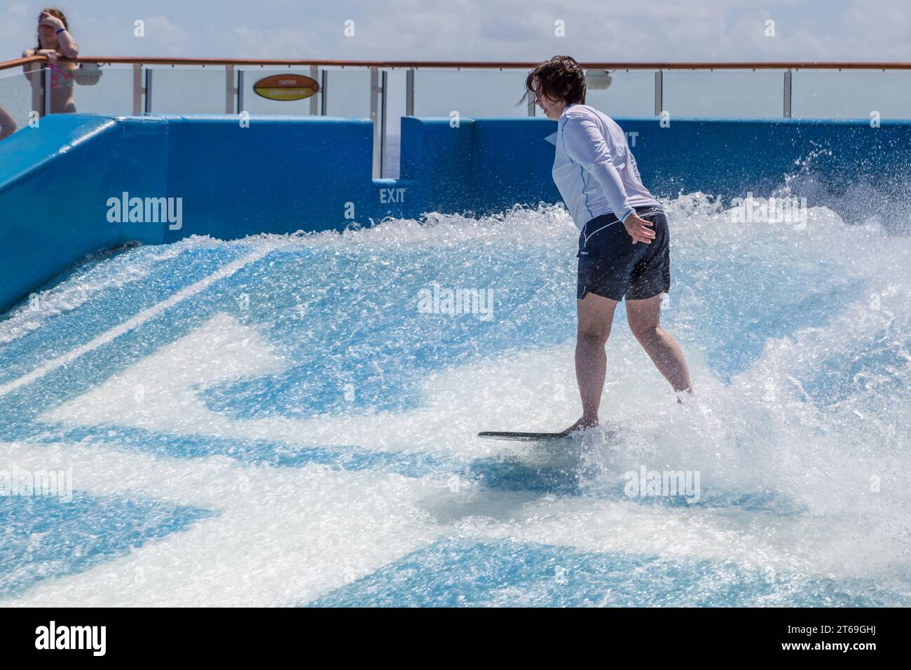 Woman surfing at the Flowrider activity on the Royal Caribbean Allure ...