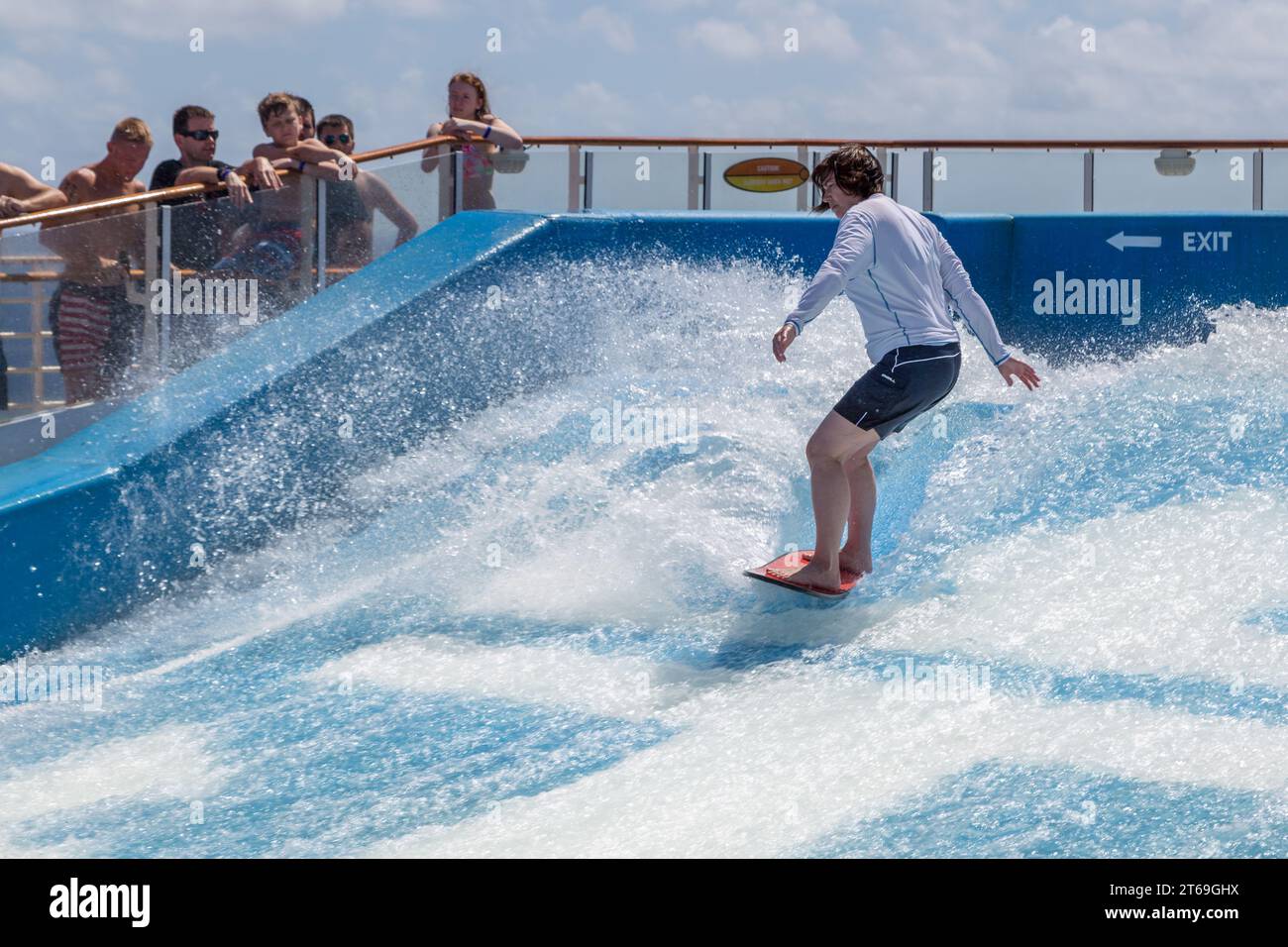 Woman surfing at the Flowrider activity on the Royal Caribbean Allure ...
