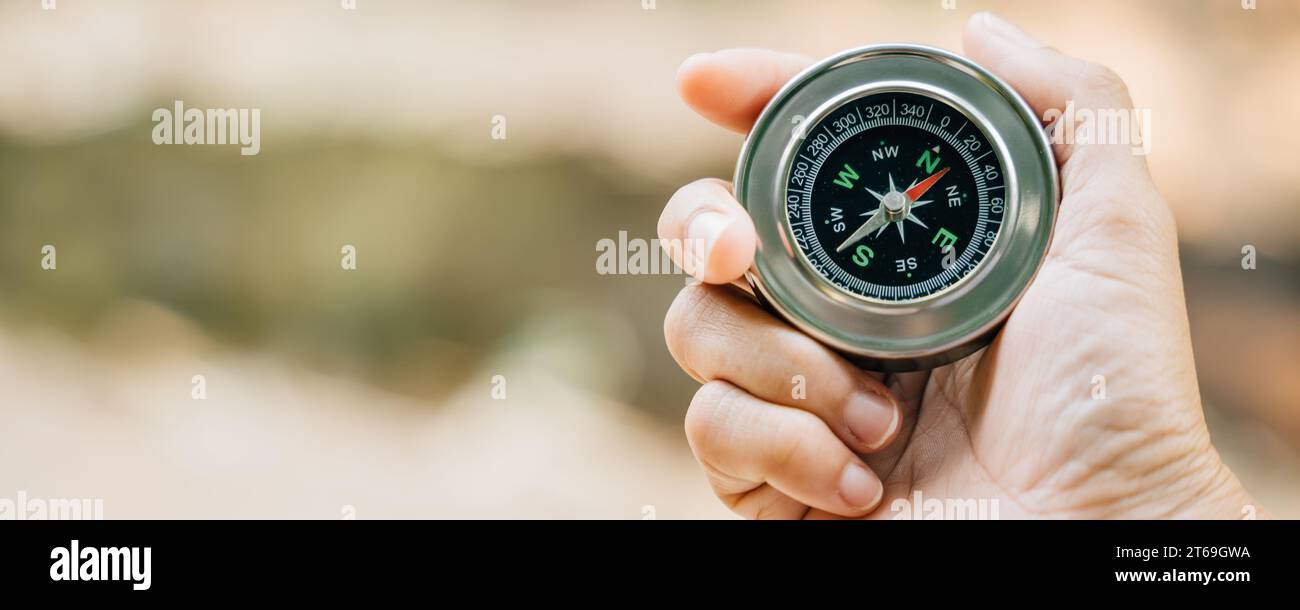 Traveler holds a compass in park seeking guidance amidst the beauty of ...