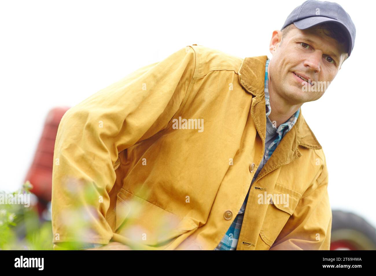 The lifestyle of a true farmer. Portrait of a farmer kneeling in a ...