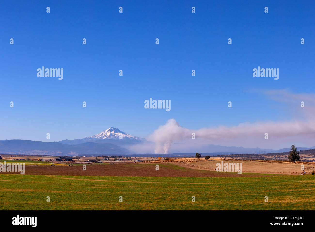 A controlled burn can be seen off in the distance from highway 26 with ...