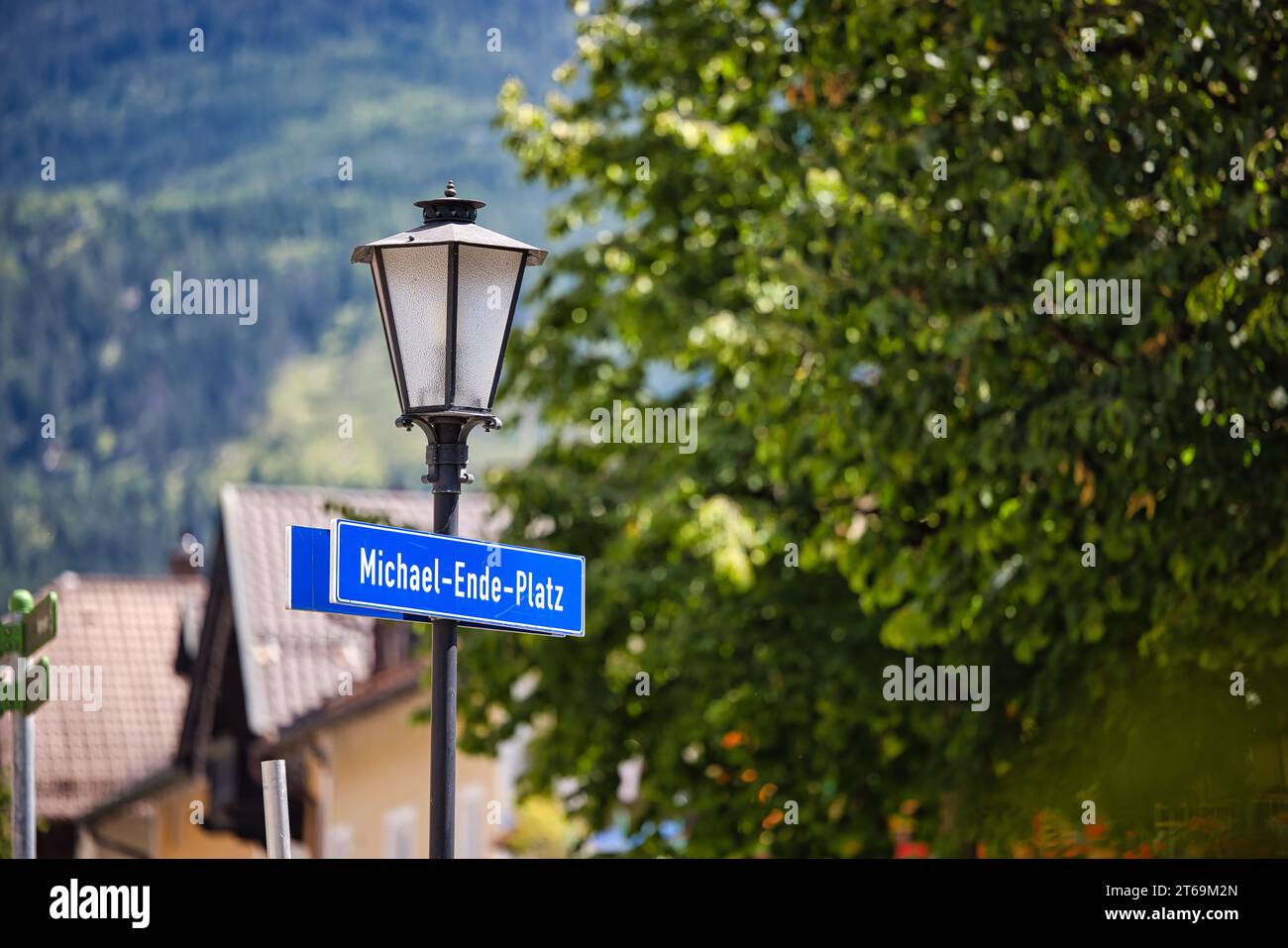 A vibrant street sign displaying the name 'Michael-Ende-Platz' against ...