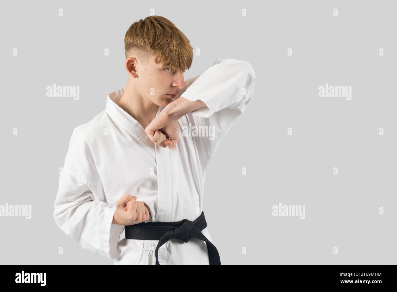 Black belt teenage boy strikeing with his elbow Stock Photo - Alamy