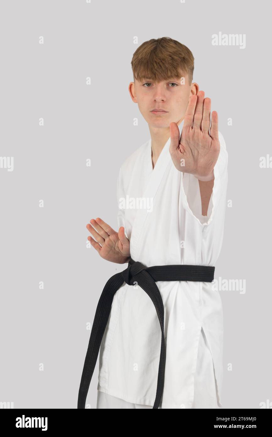 Black belt teenage boy performing a palm heel strike Stock Photo - Alamy