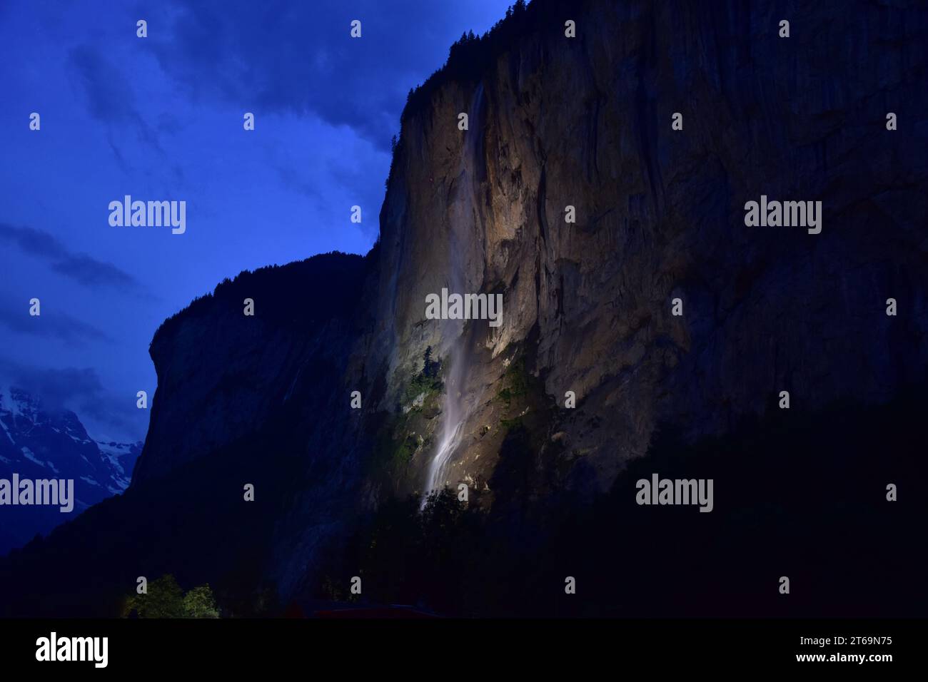 A stunning night scene of a cascading waterfall illuminated with ...