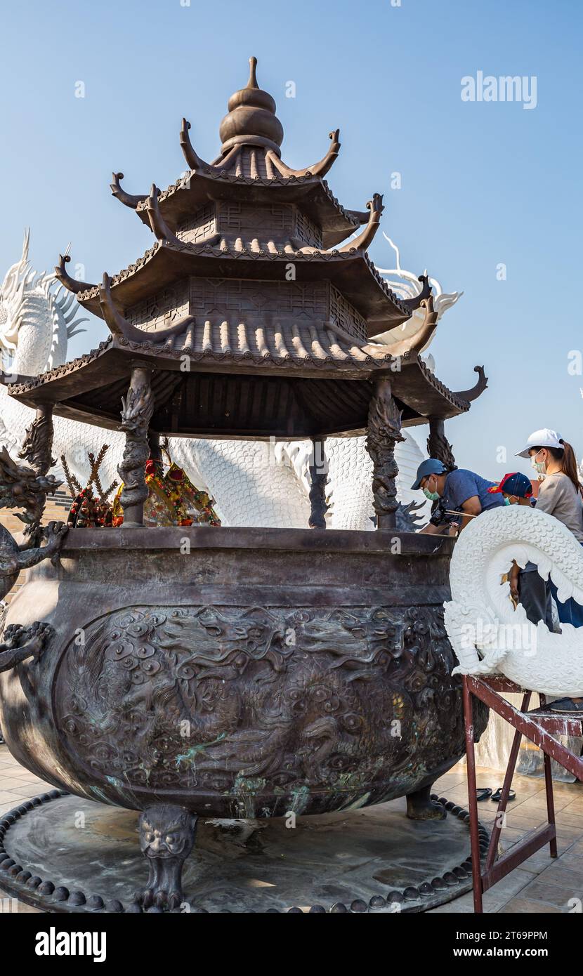 Visitors make a wai phra offering to Buddah in front of the Guan Yin ...