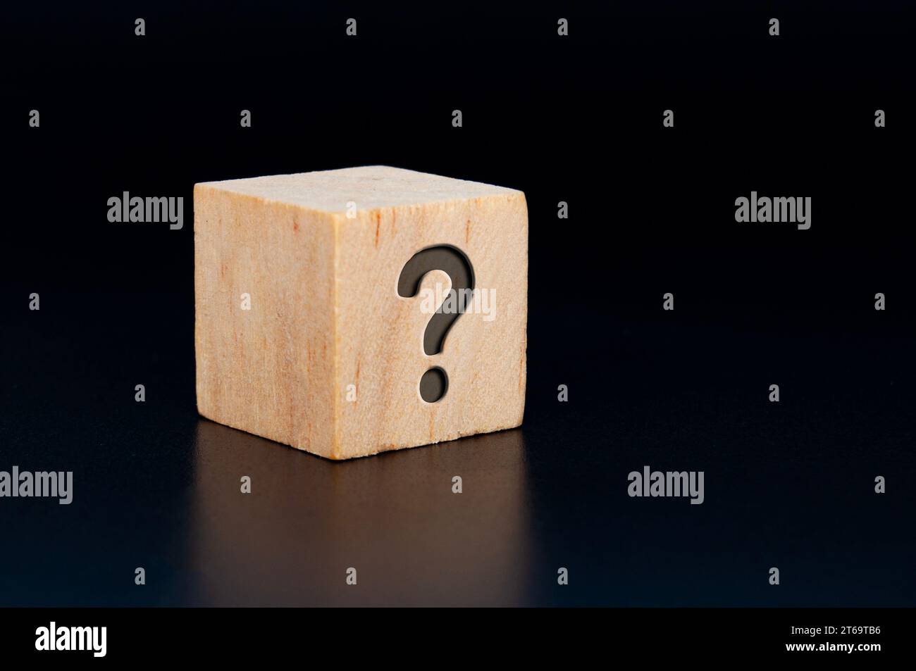 Question mark engraved on wooden cube with dark background. Question ...