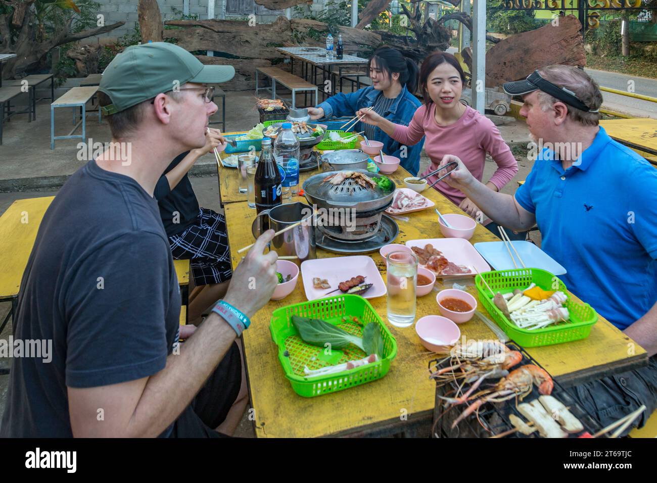 American missionaries cooking food on a charcoal grill and hot pot at a ...