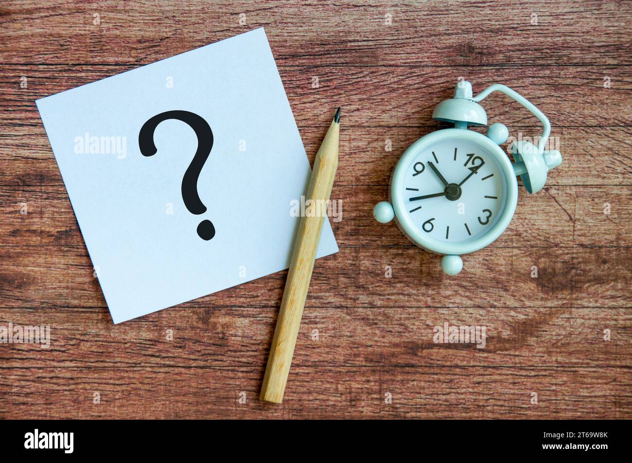 Top view of question mark on notepad with pencil and alarm clock ...
