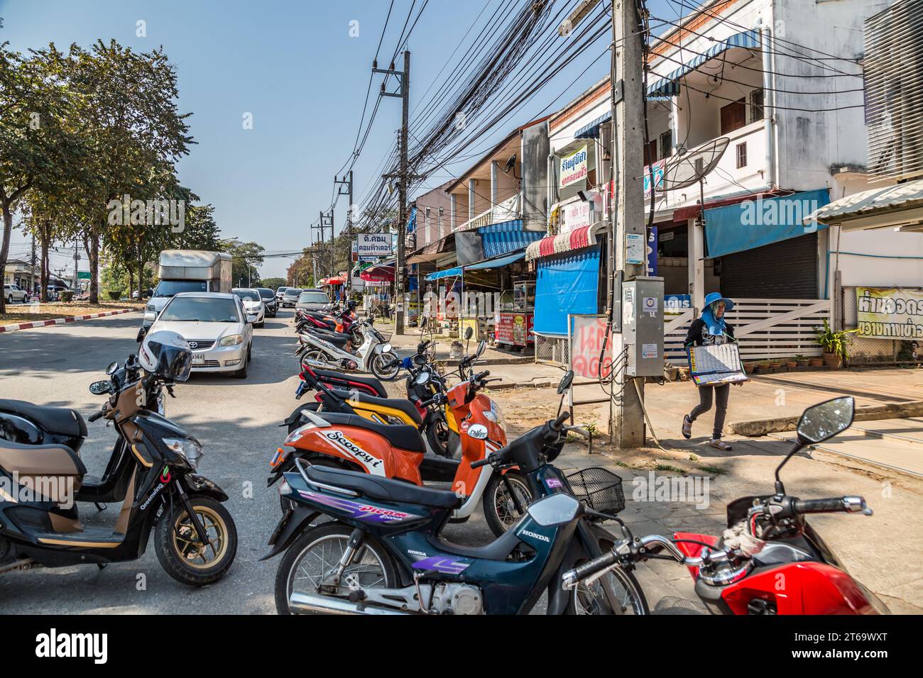 Cars and scooters double parked along Ban Du street in Chiang Rai ...